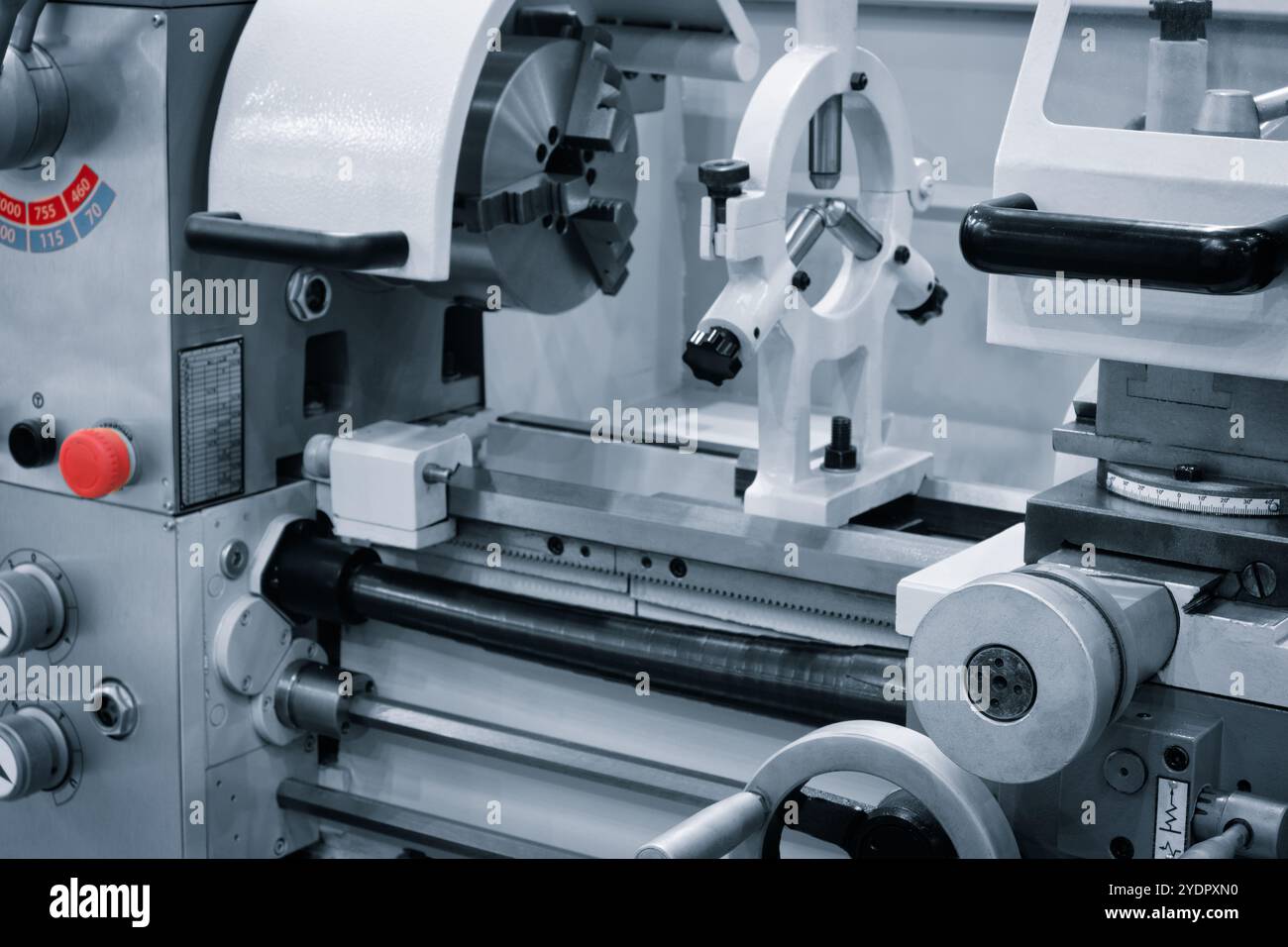 A machine with a red button on the front. The machine is a lathe. The ...