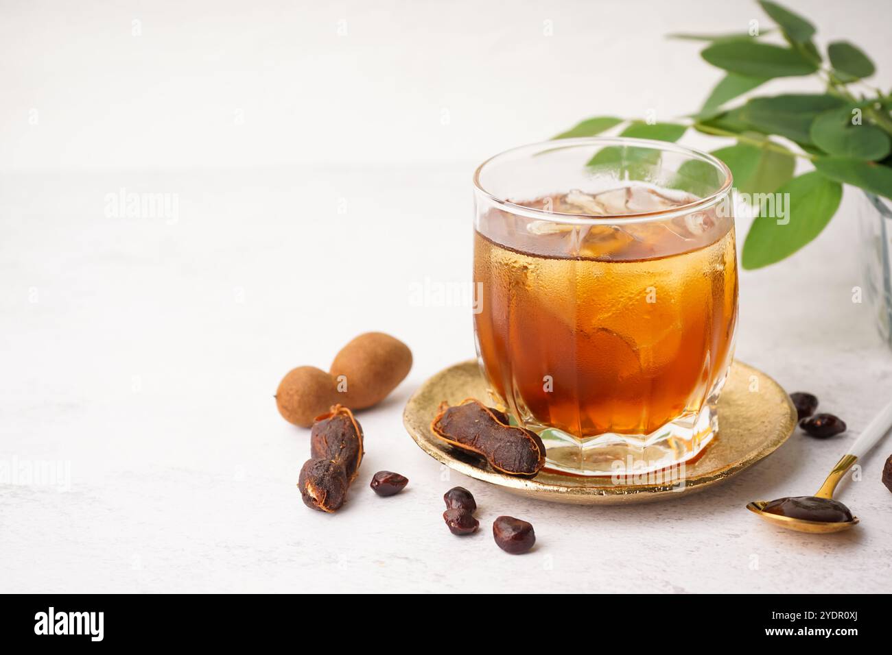 Glass of tasty tamarind drink and fruits on white background Stock ...