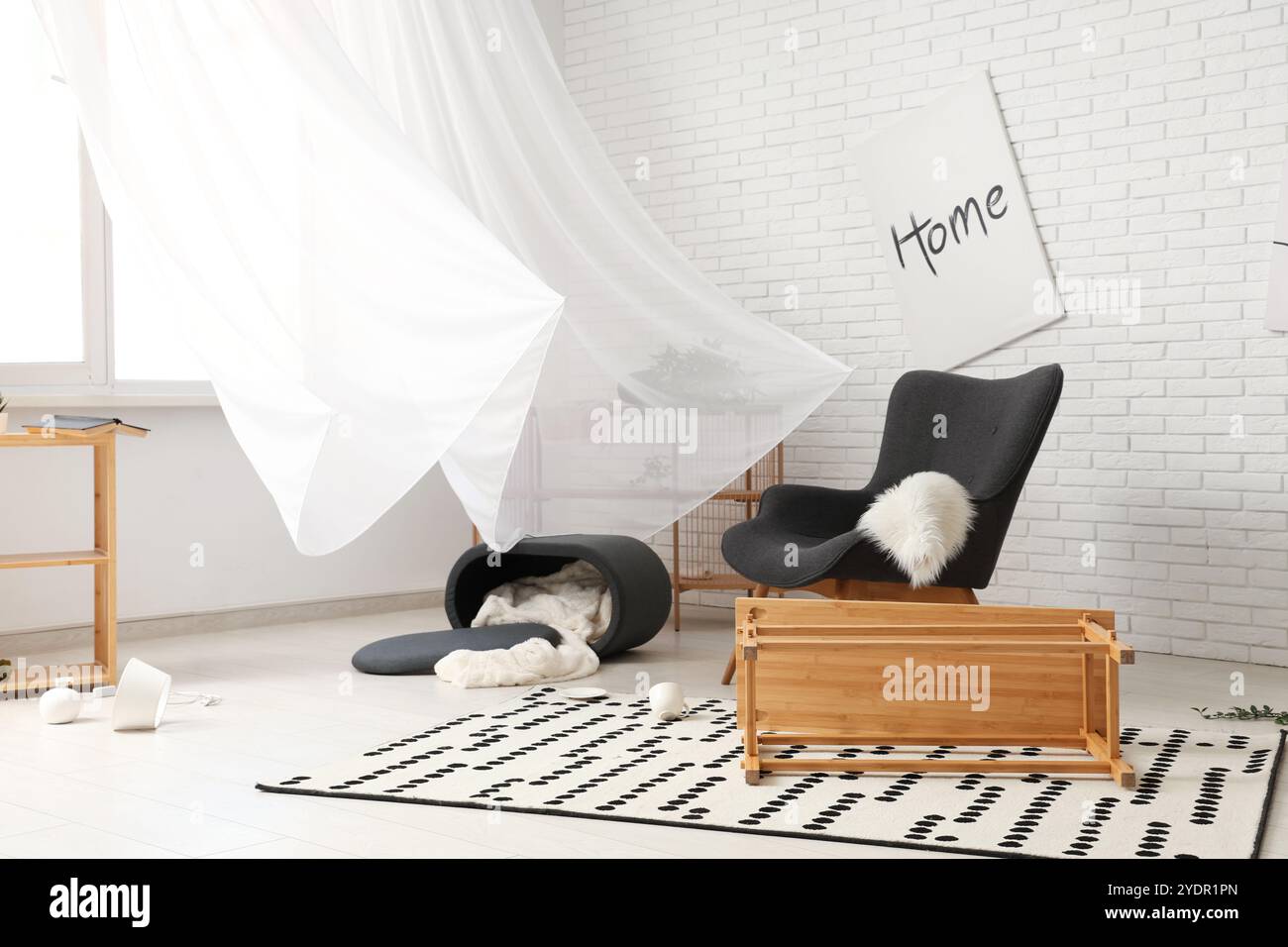 Interior of messy living room with armchair and overturned coffee table ...