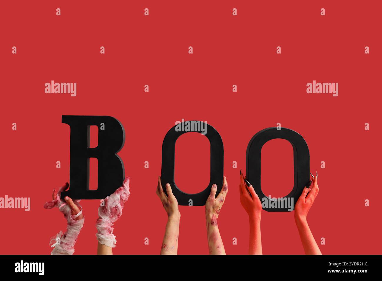 Mummy, zombie and devil hands holding word BOO on red background ...