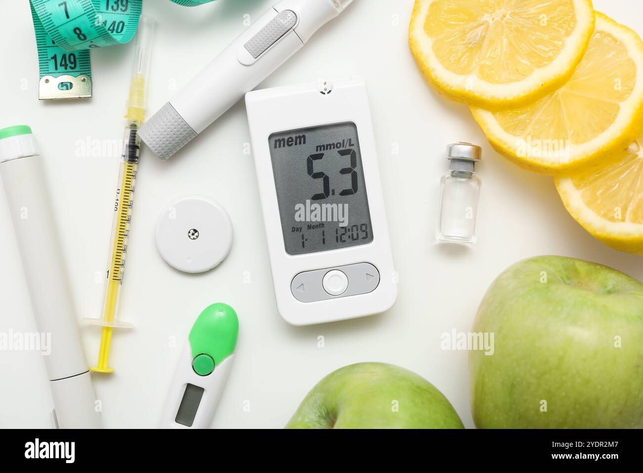 Glucometer with lancet pens, insulin and fruits on white background ...