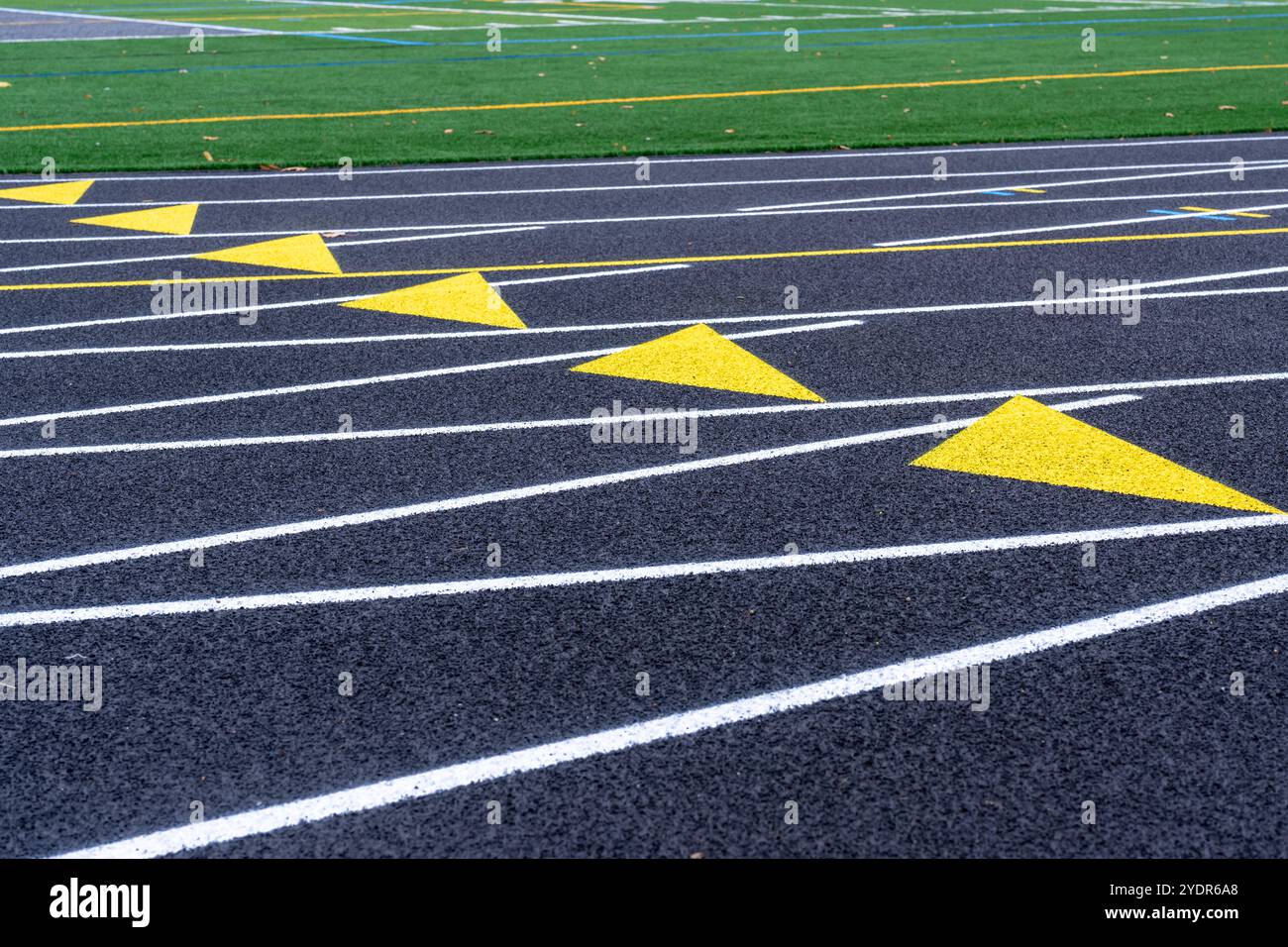 Close up of yellow exchange zone markings on a new black running track ...