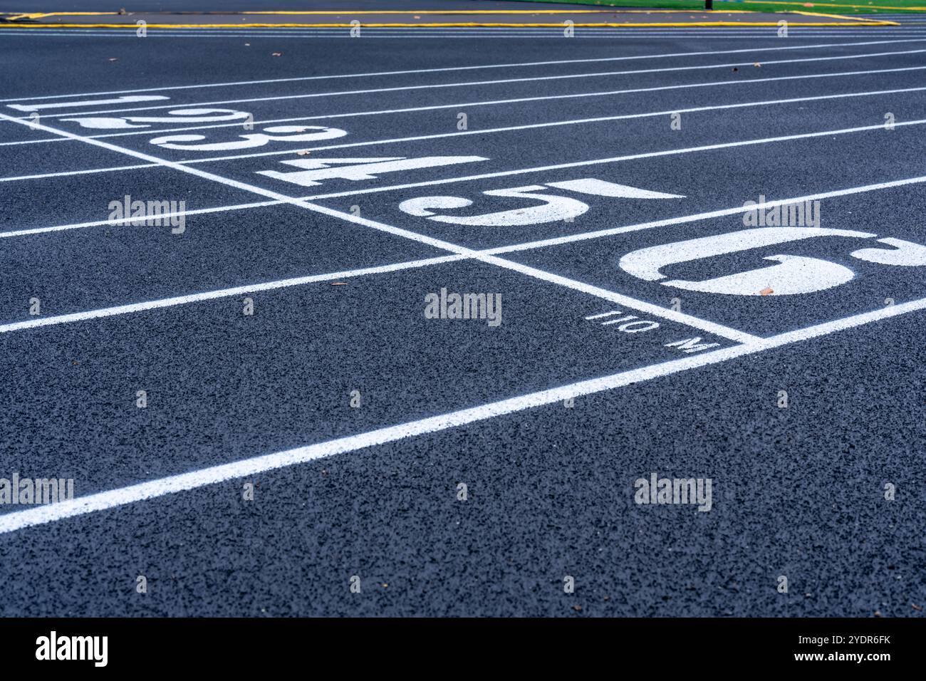 Afternoon photo of new black running track with white lane number 1, 2 ...