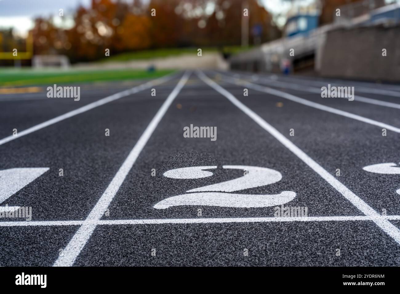 Close up lane number 2 on a new black running track with white lane ...