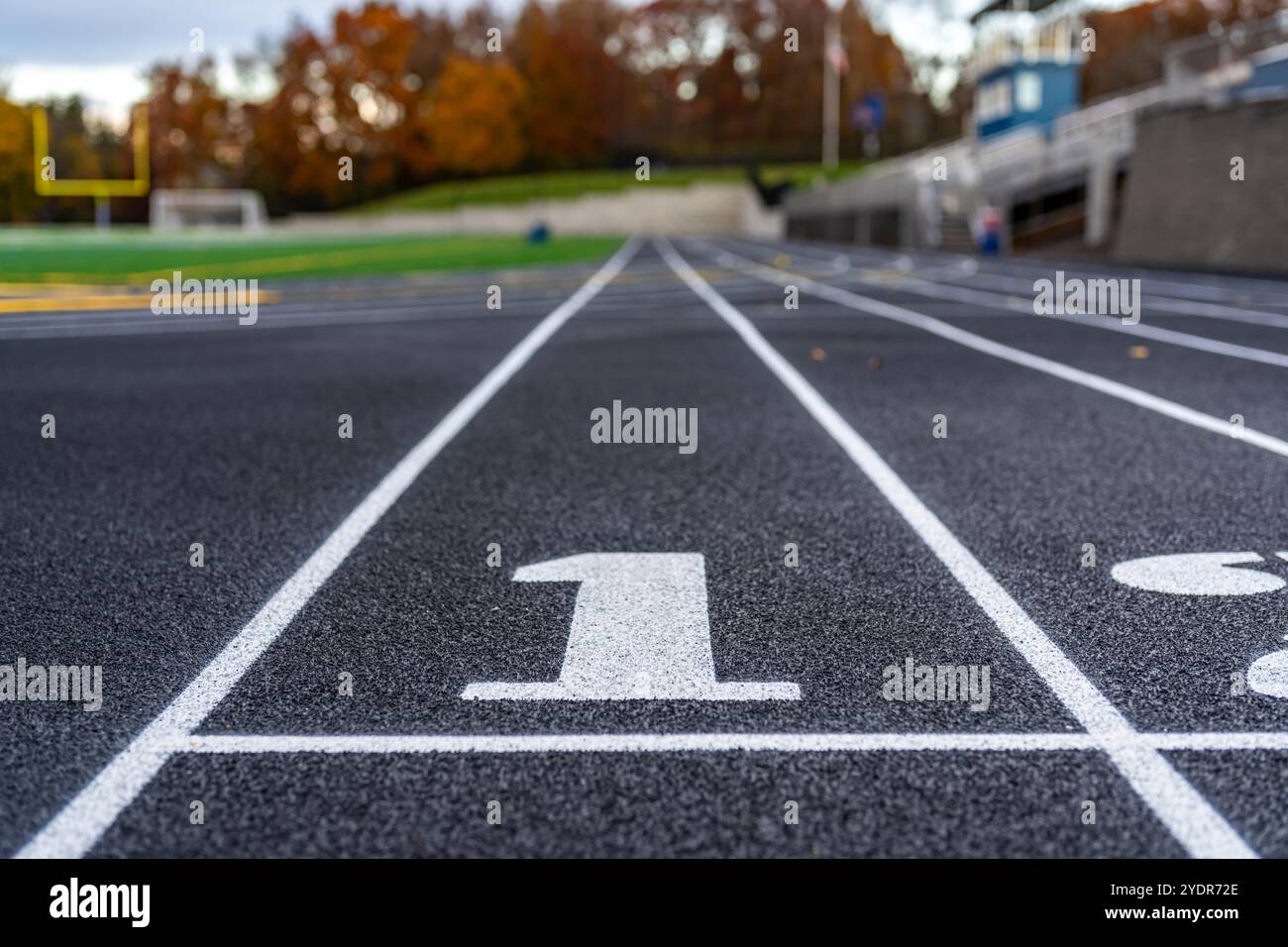Close up lane number 1 on a new black running track with white lane ...