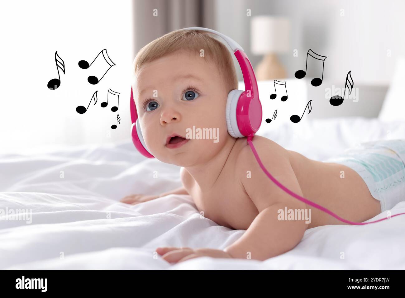 Cute little baby with headphones on bed at home. Music notes flying ...