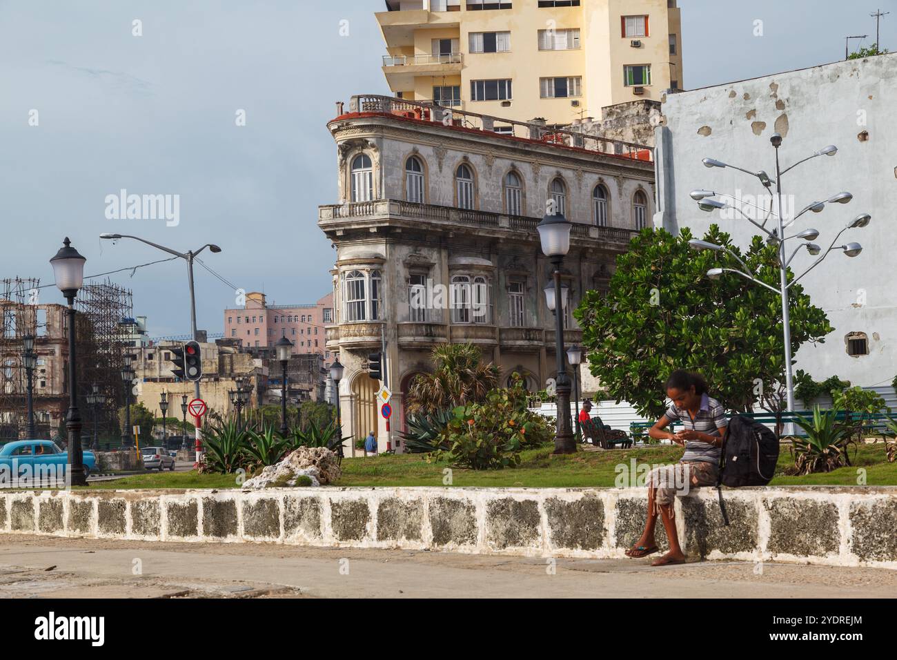 A girl sitting and an Odd shaped three story building in Malecon, La ...