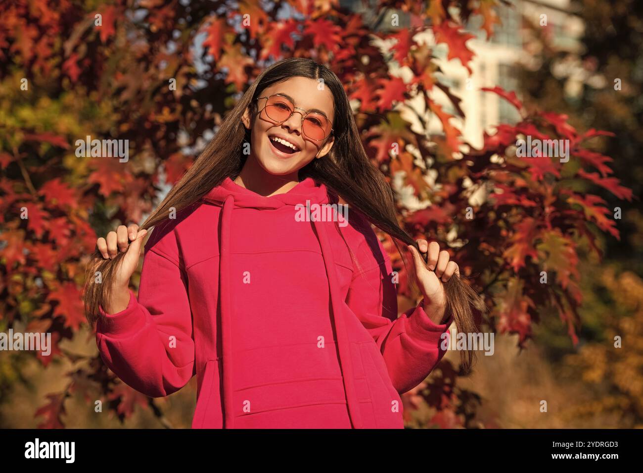 Fall style fashion. Autumn leaves and happy young girl in forest. The ...