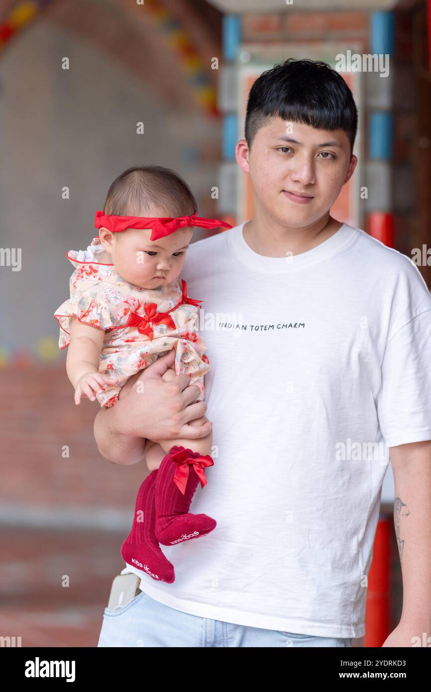 A Taiwanese couple in their 20s and their 7-month-old baby celebrate a ...