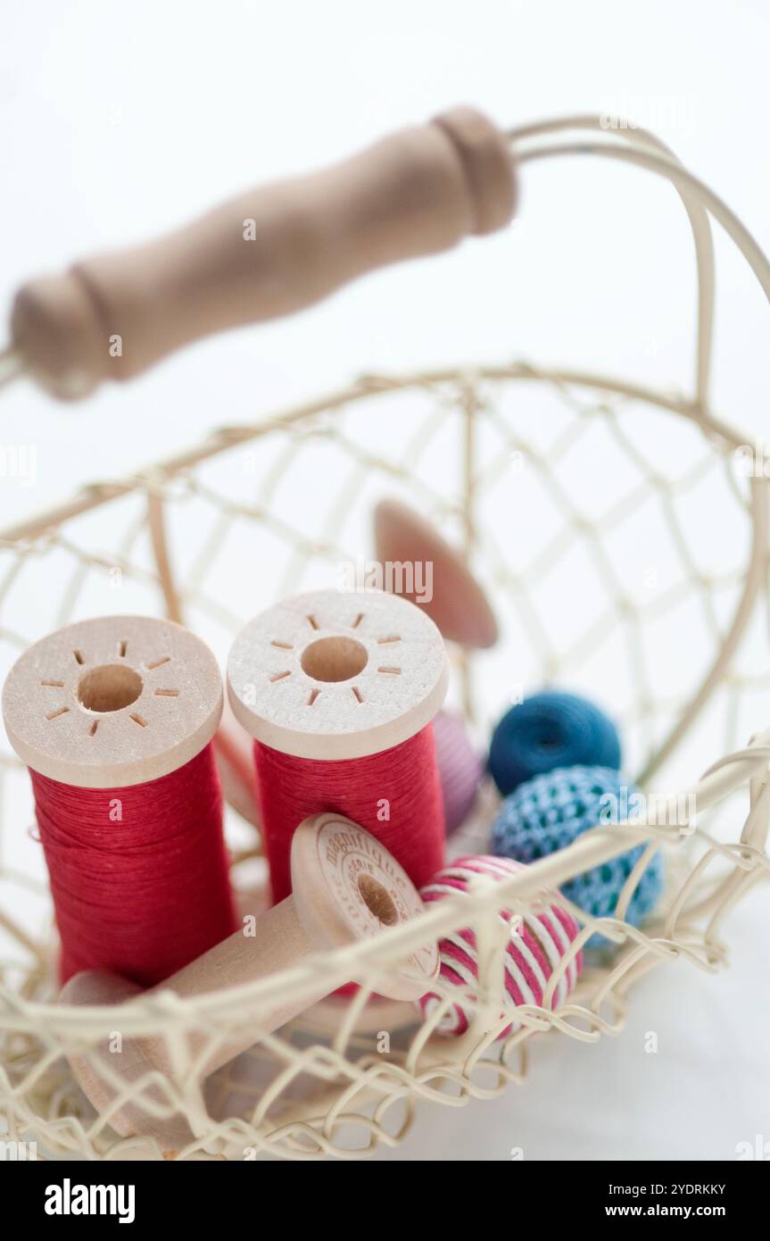 Spool of thread and buttons in wire basket Stock Photo - Alamy