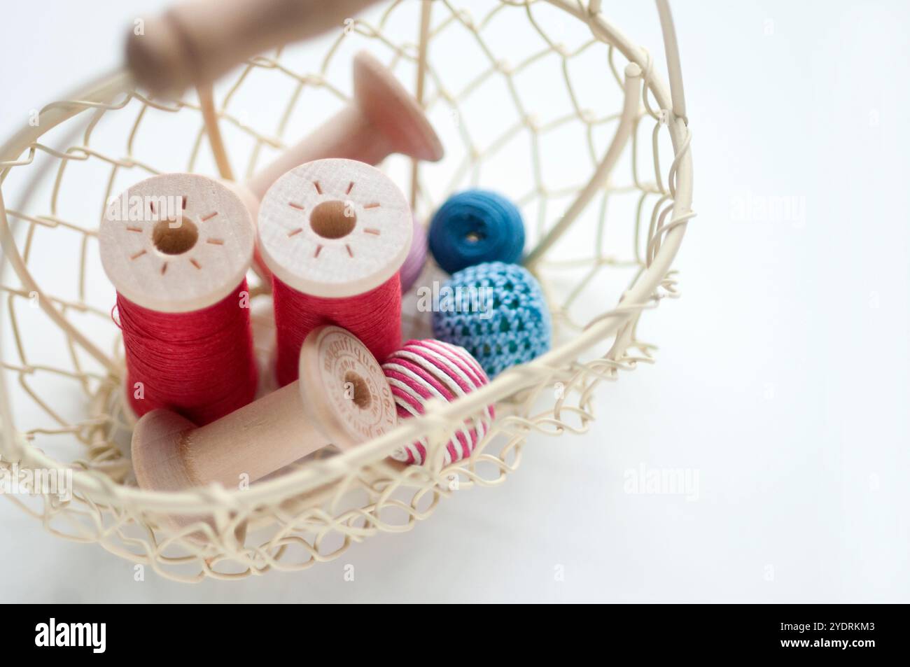 Spool of thread and buttons in wire basket Stock Photo - Alamy