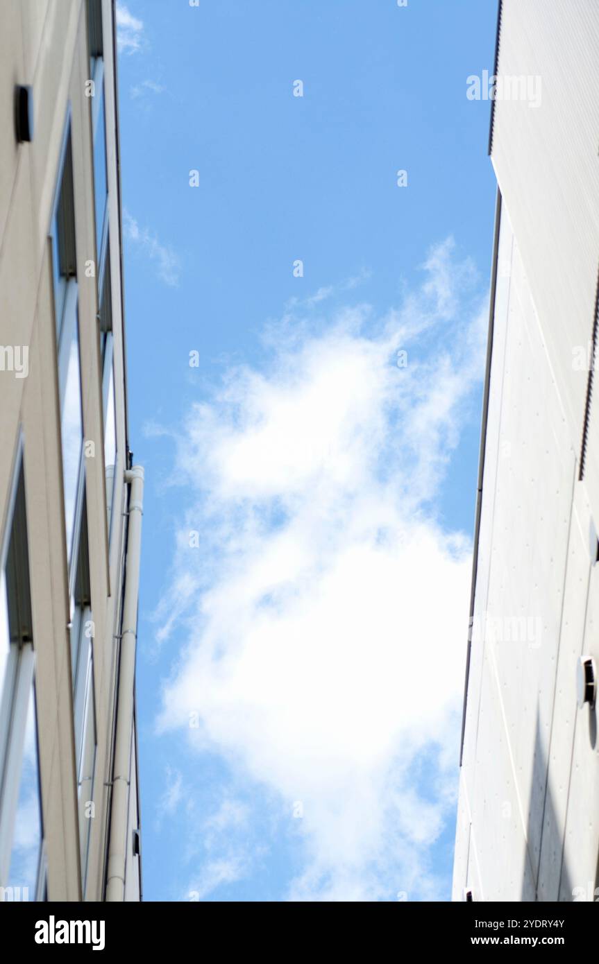 Blue sky seen through gap between buildings Stock Photo - Alamy
