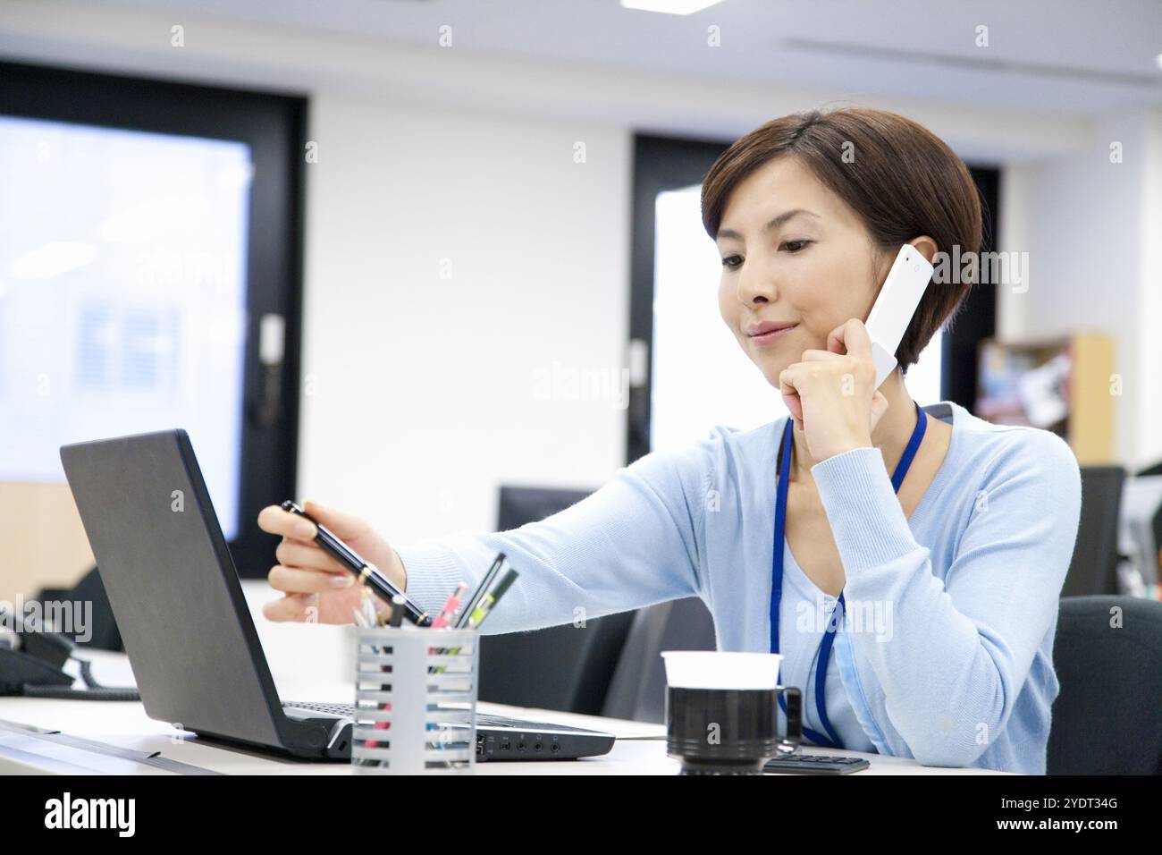 Office worker making a phone call at desk Stock Photo - Alamy