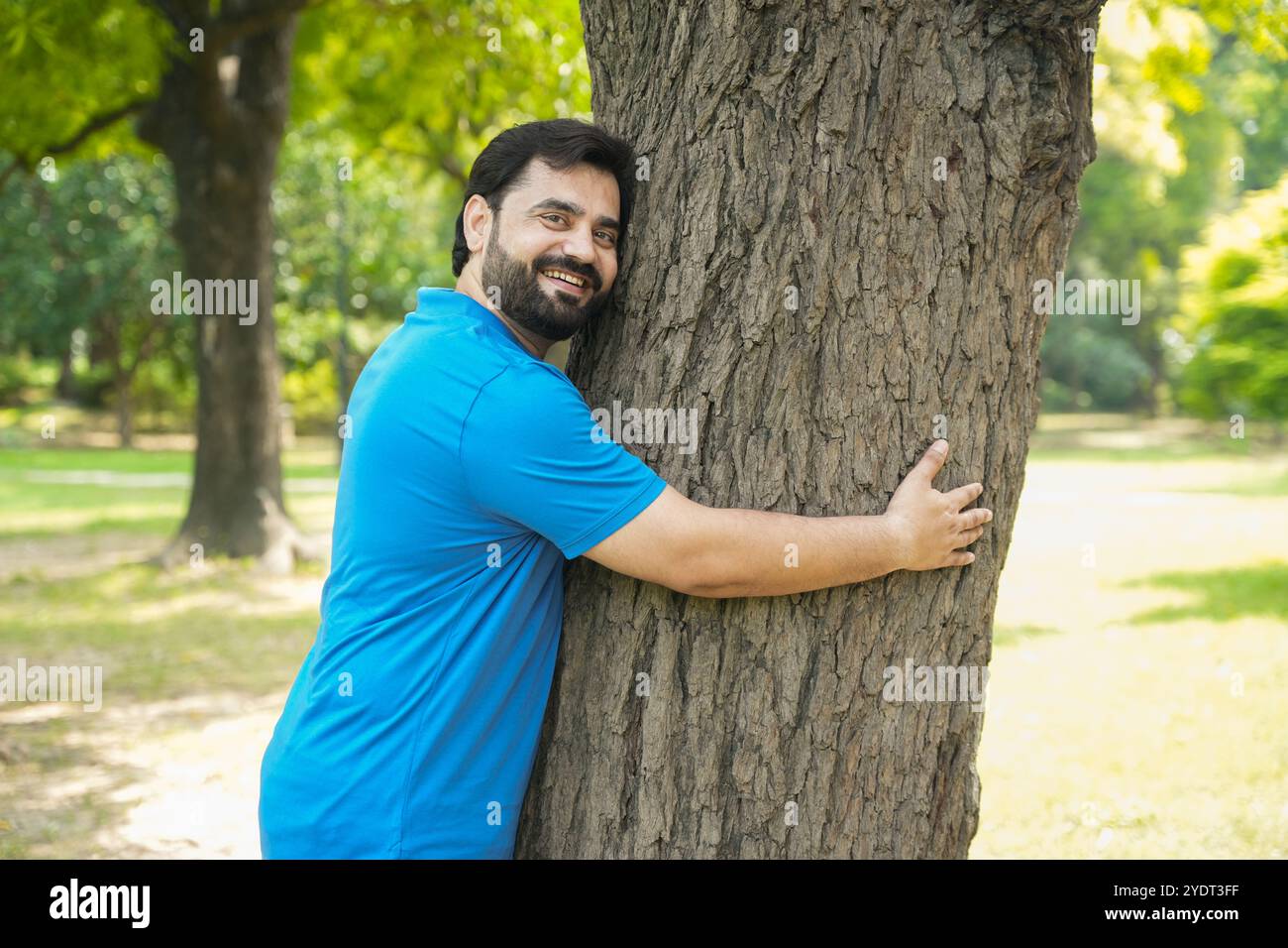young indian man embracing large tree, Save planet, ecology, climate ...