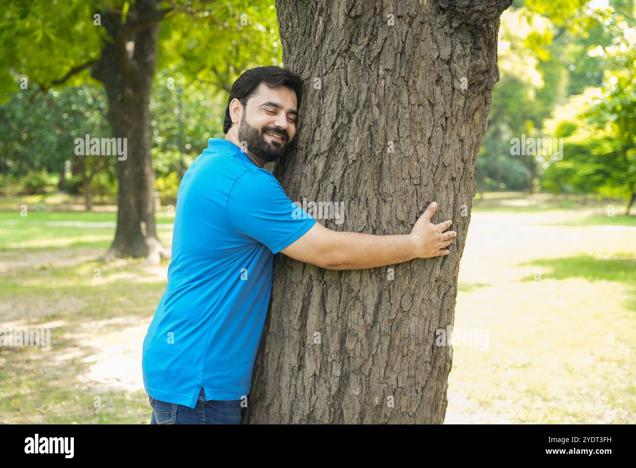 young indian man embracing large tree, Save planet, ecology, climate ...