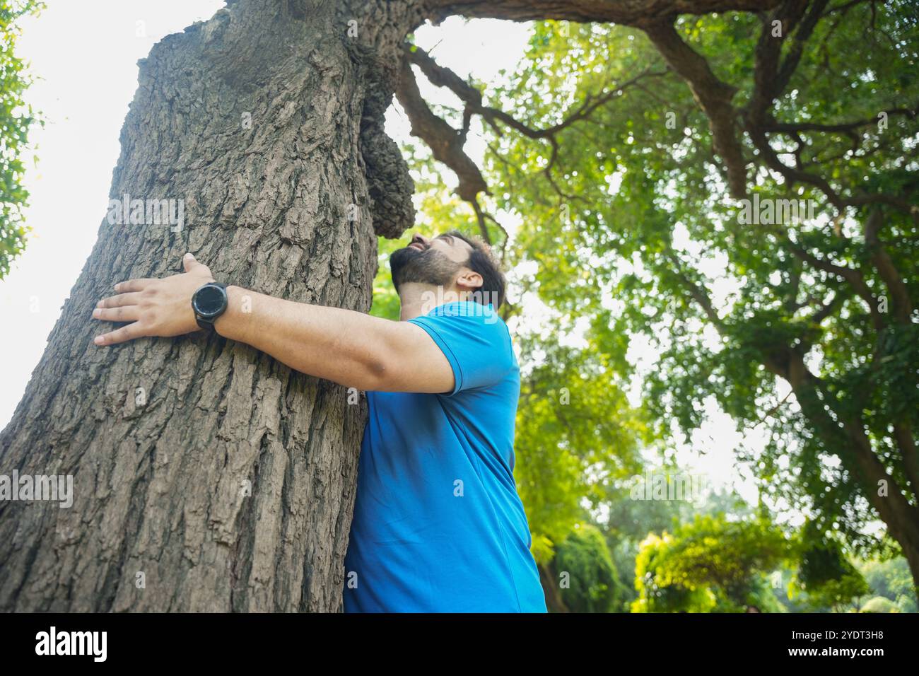 young indian man embracing large tree, Save planet, ecology, climate ...