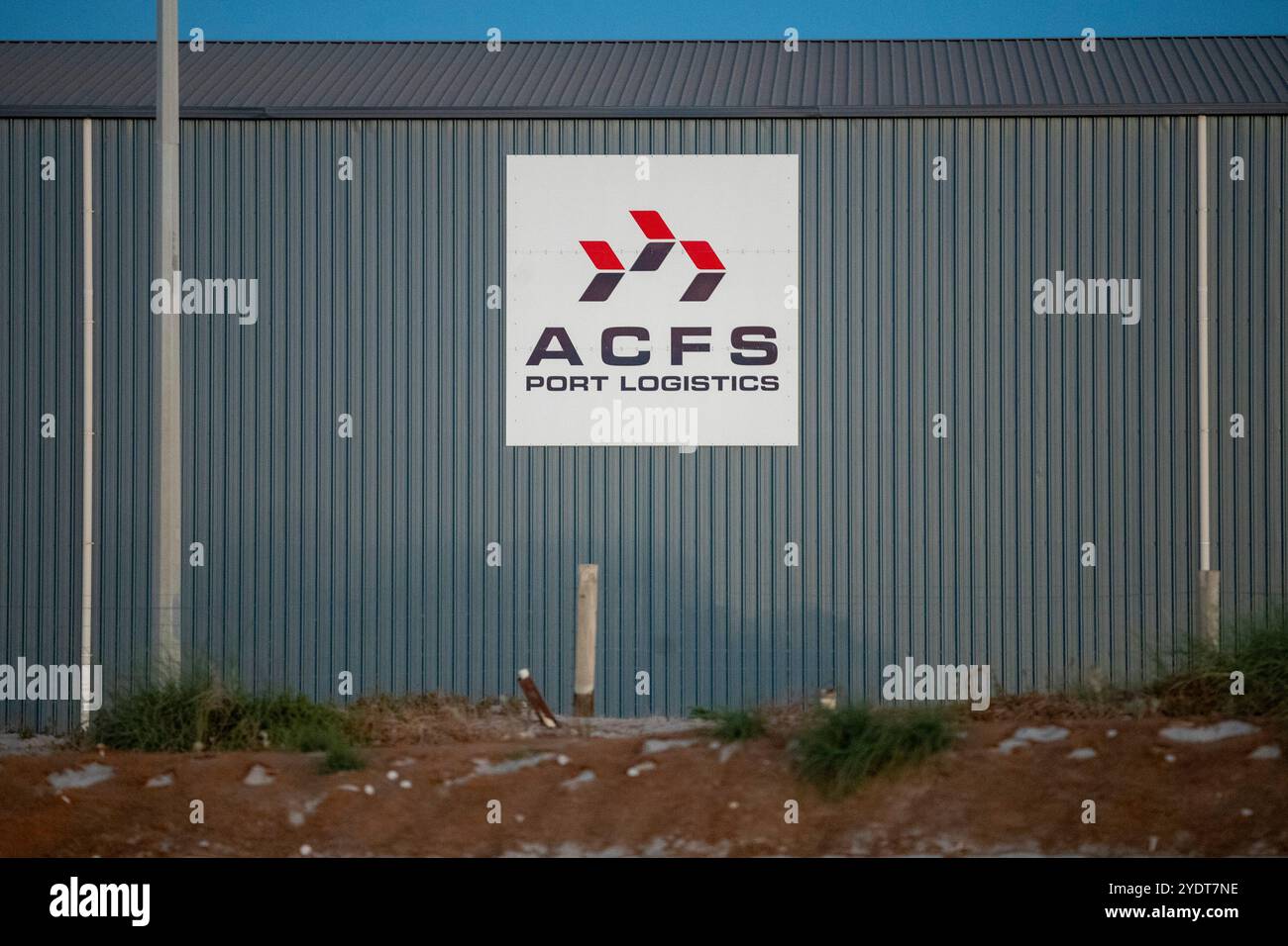 This image shows the exterior of a logistics warehouse with a sign for ...