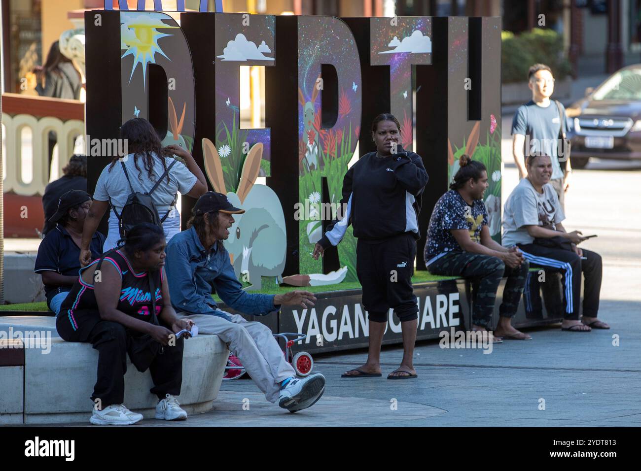 A group of homeless Aboriginal Australians gathered around a large ...