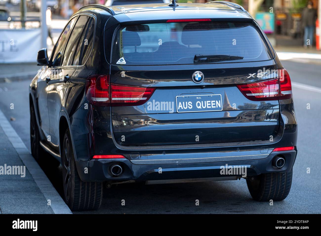 black BMW X5 parked on a city street, with a personalized license plate ...