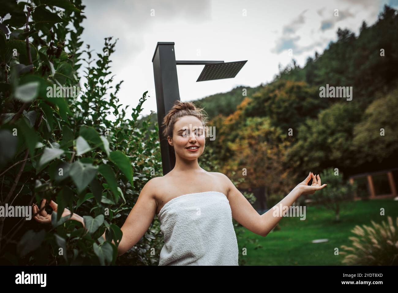 Beautiful woman resting in garden after using home sauna. Woman taking ...