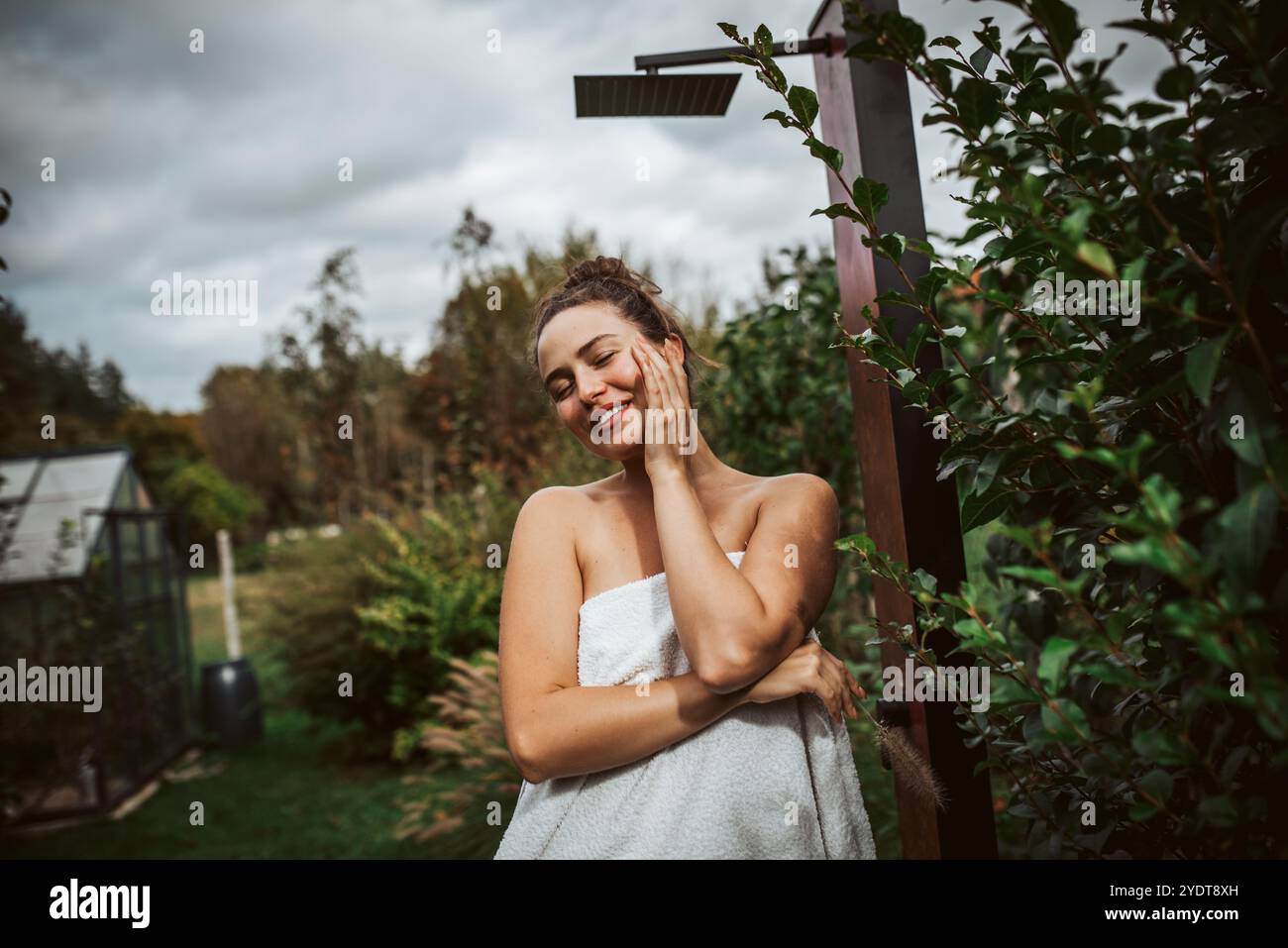 Beautiful woman resting in garden after using home sauna. Woman taking ...