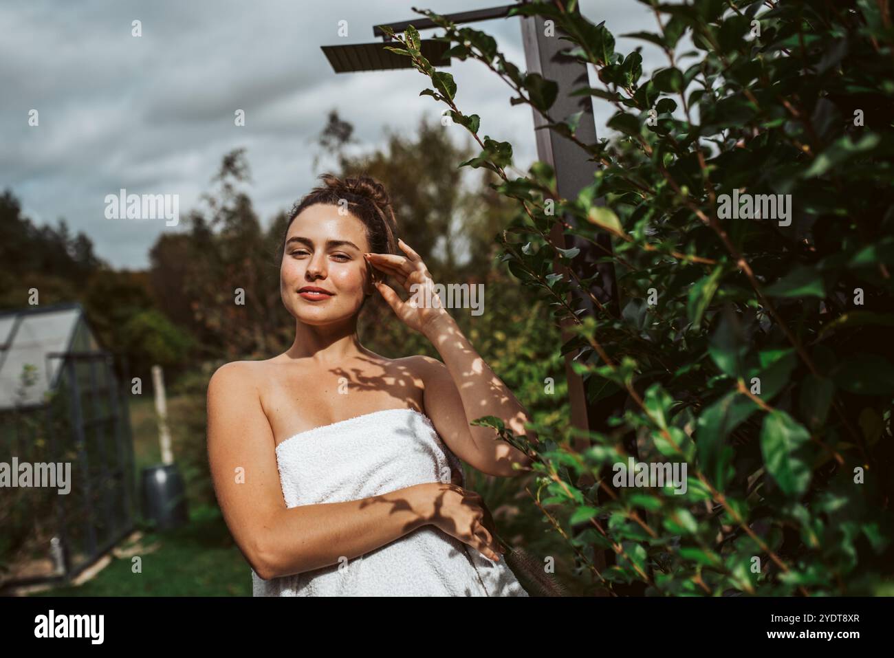 Beautiful woman resting in garden after using home sauna. Woman taking ...