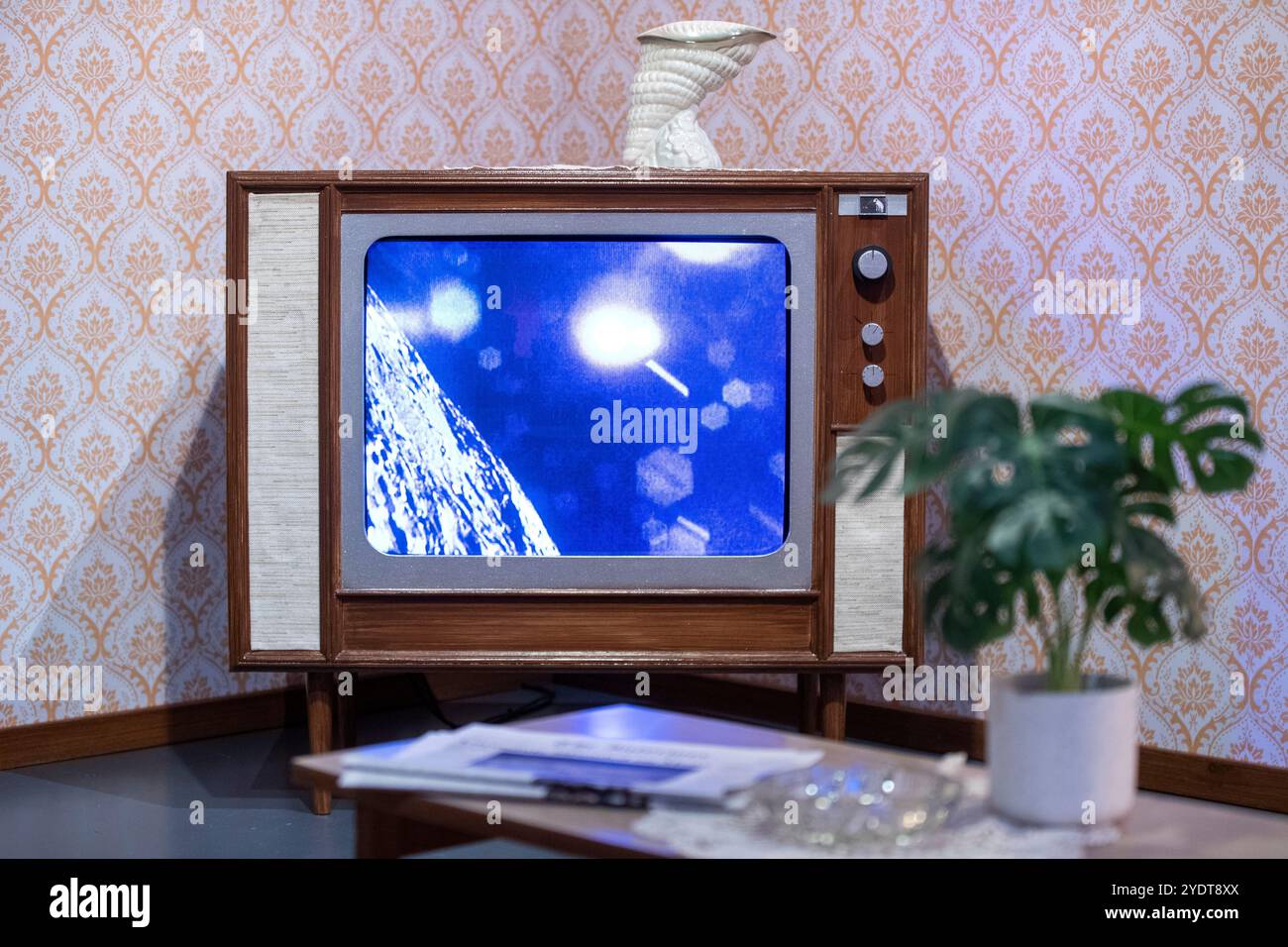 A vintage television displaying an image of space, with a view of a ...