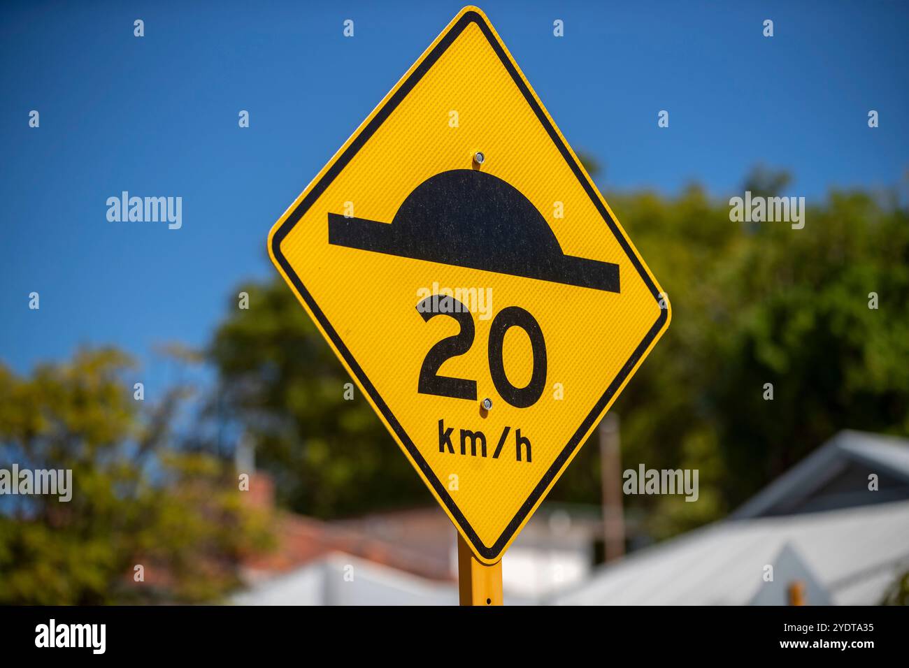 A vibrant yellow road sign with a black depiction of a traditional ...