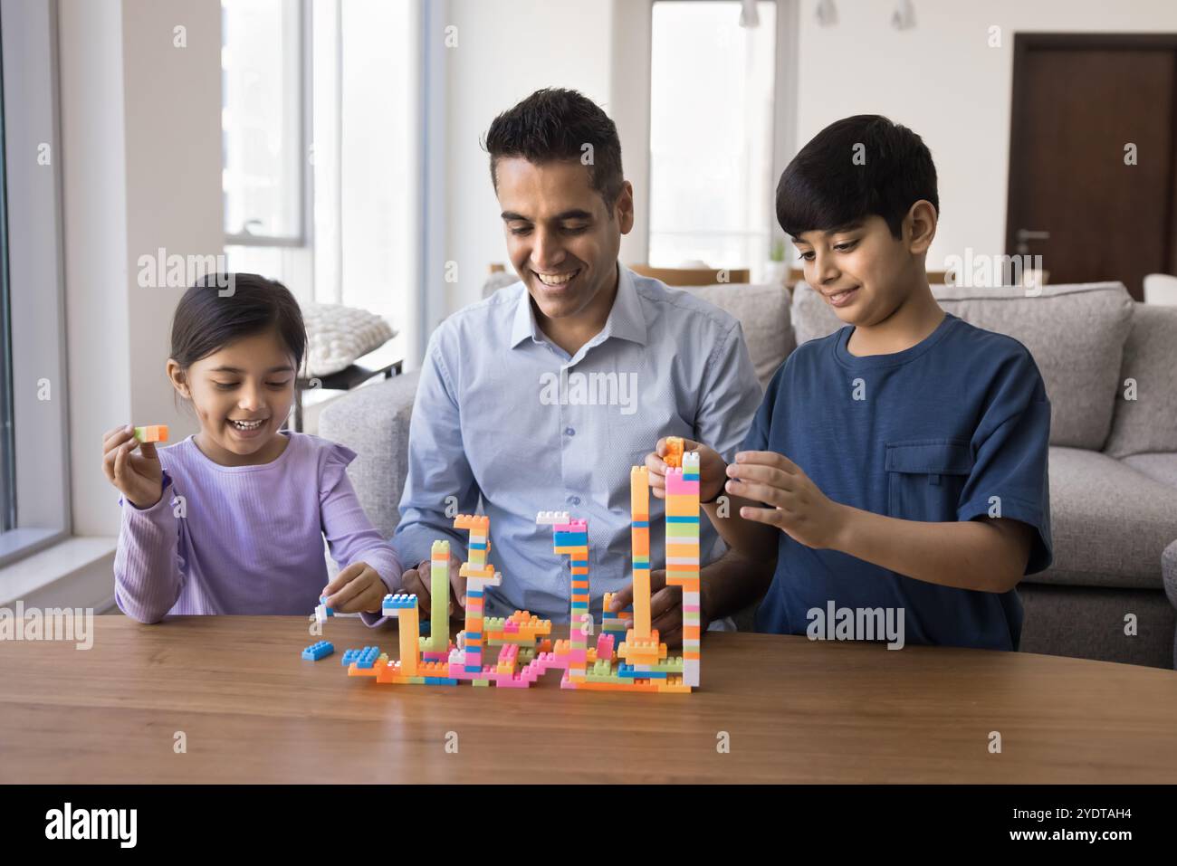 Happy Indian daddy playing construction game with kids Stock Photo - Alamy