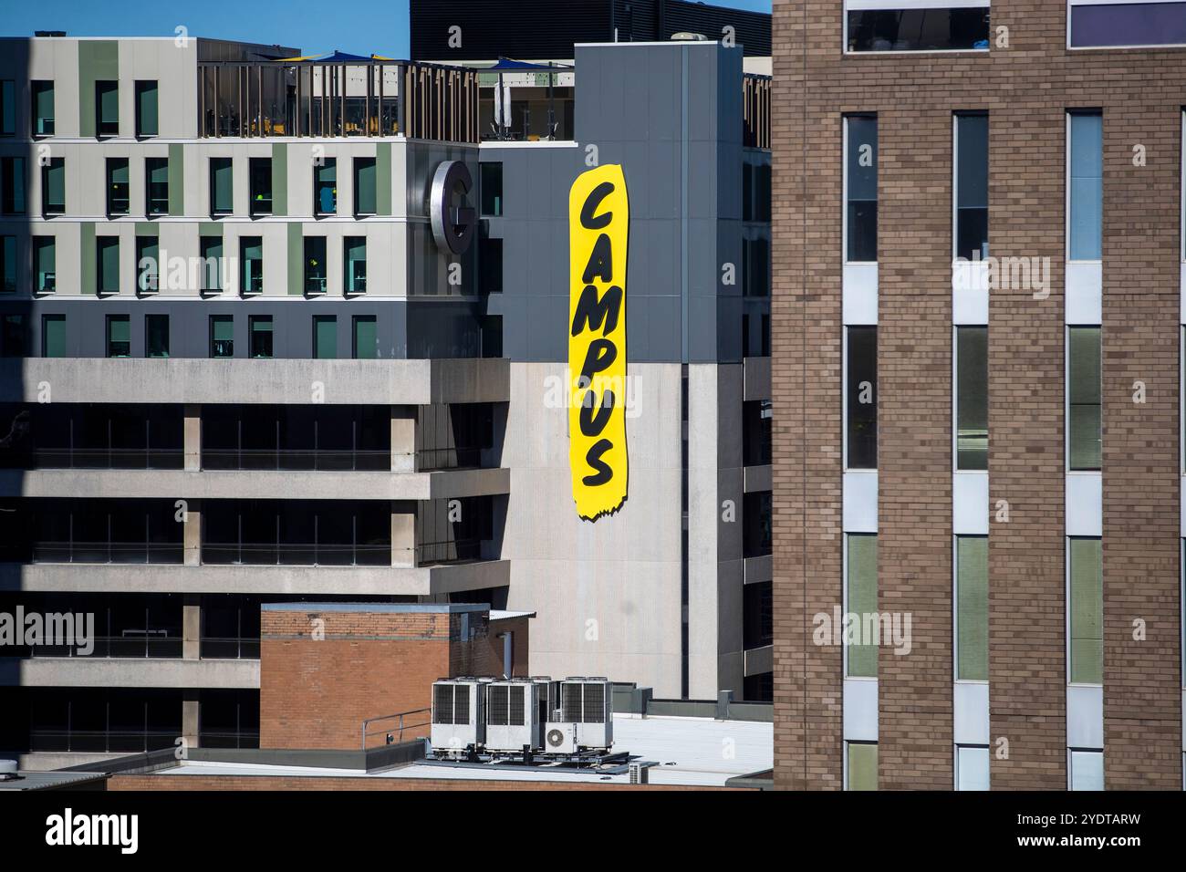 This image shows a modern campus building with a large yellow "CAMPUS ...