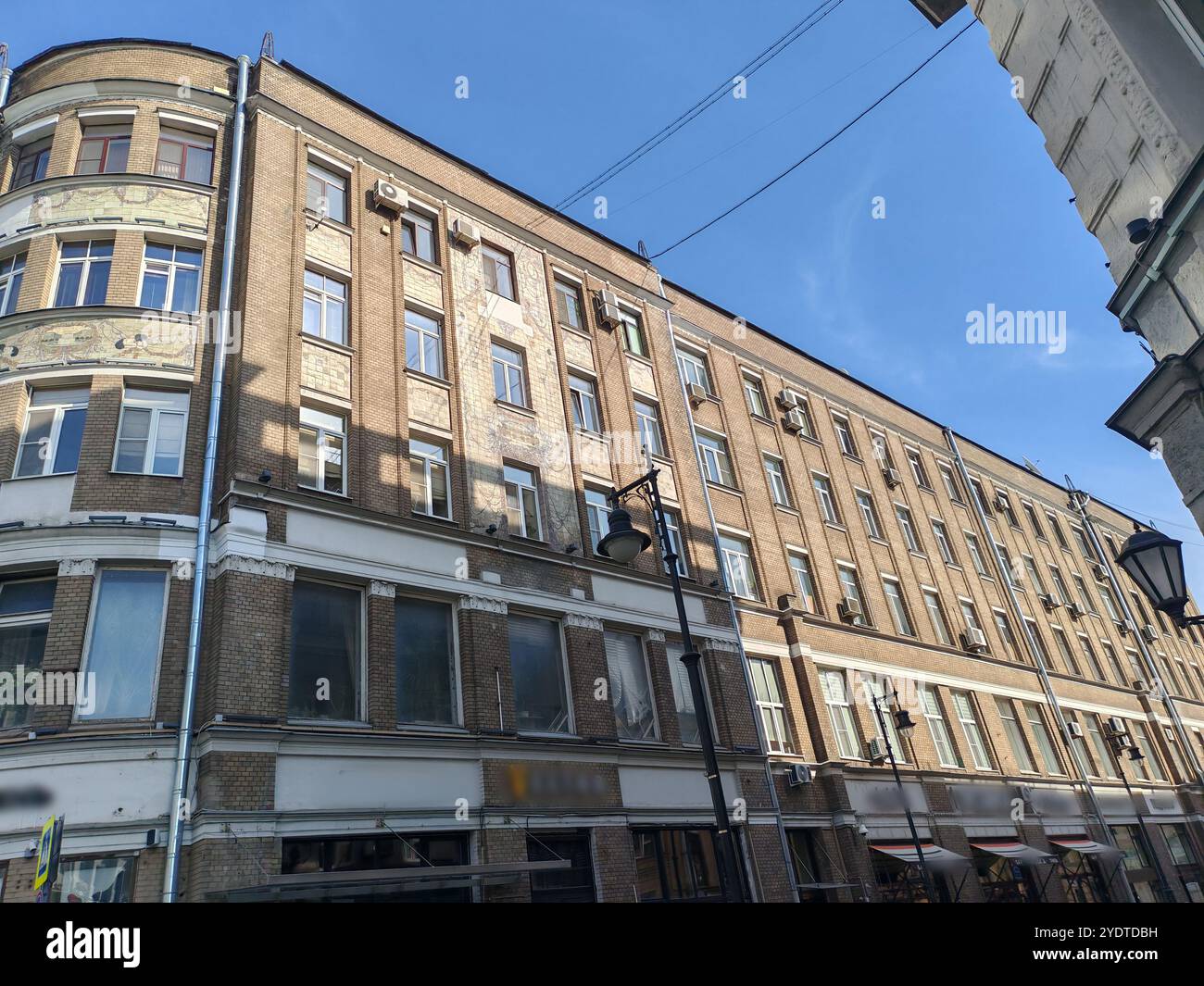 large yellow building with multiple windows and an arched doorway ...