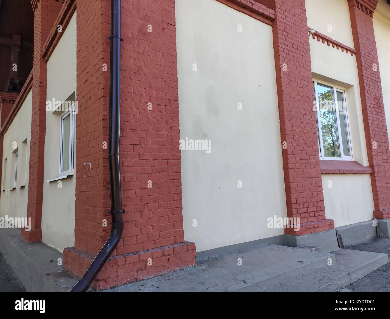 An old building with striking red brick pillars and a pitched roof ...