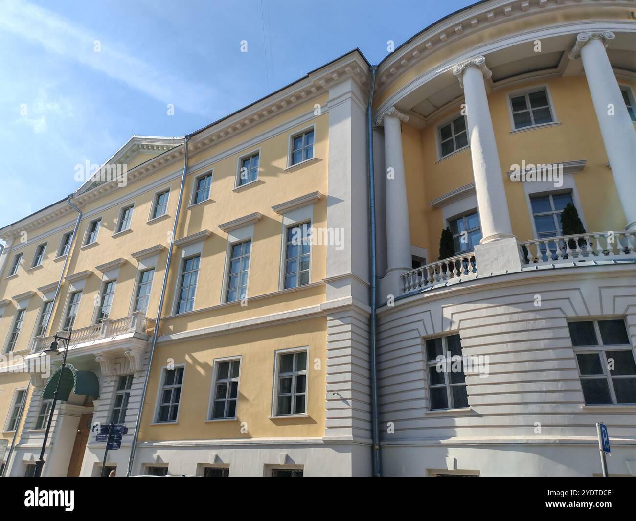 large yellow building with multiple windows and an arched doorway ...