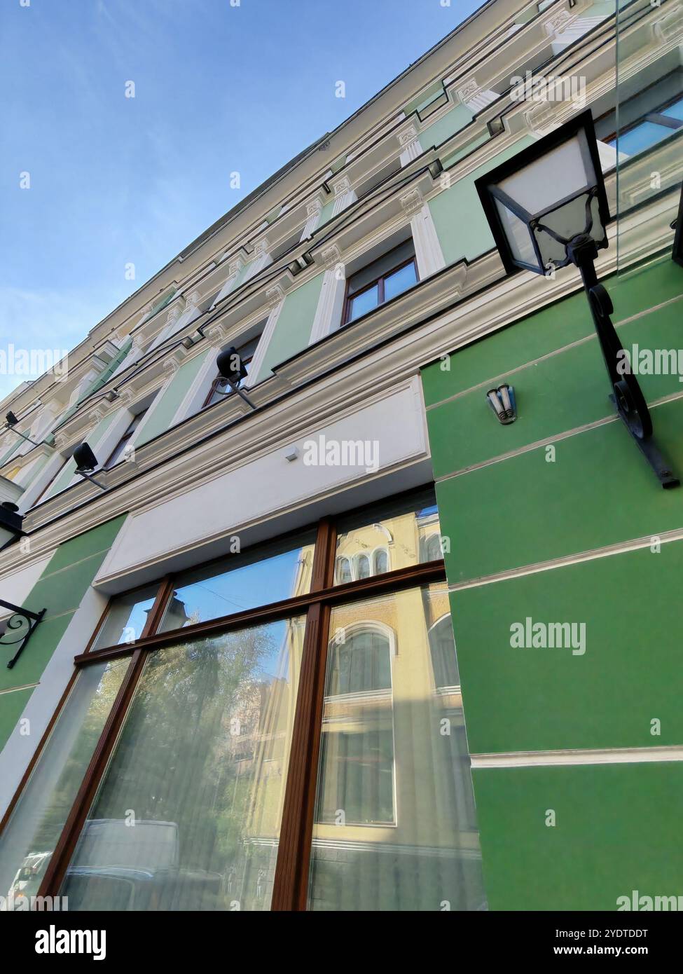green storefront with expansive windows and decorative iron lanterns ...