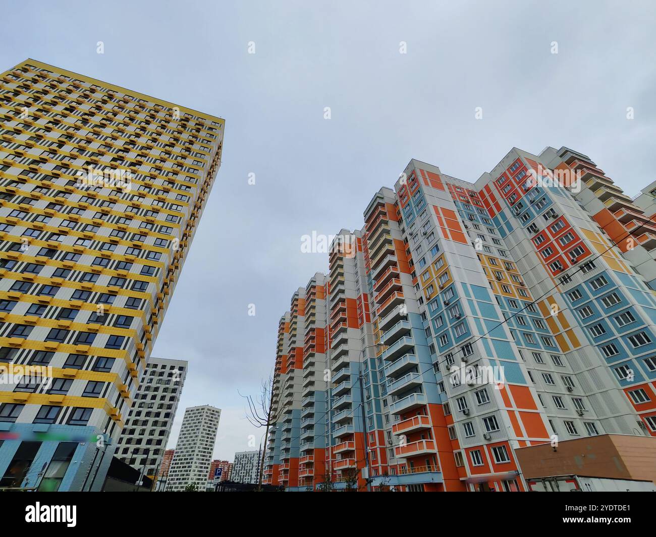 A pastel-colored high-rise residential building with curved balconies ...