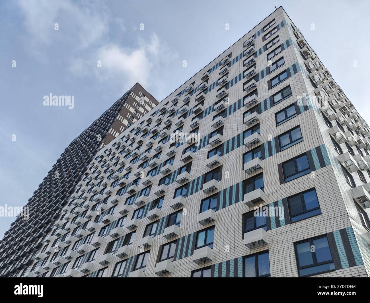 Two modern high-rise apartment buildings, one with a yellow and white ...
