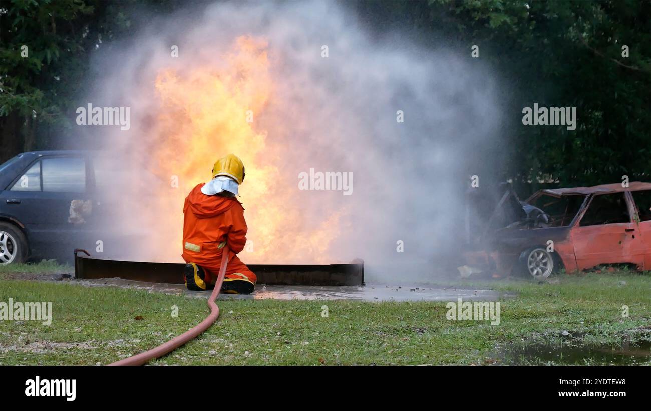 Firefighter fighting with flame using fire hose chemical water foam ...