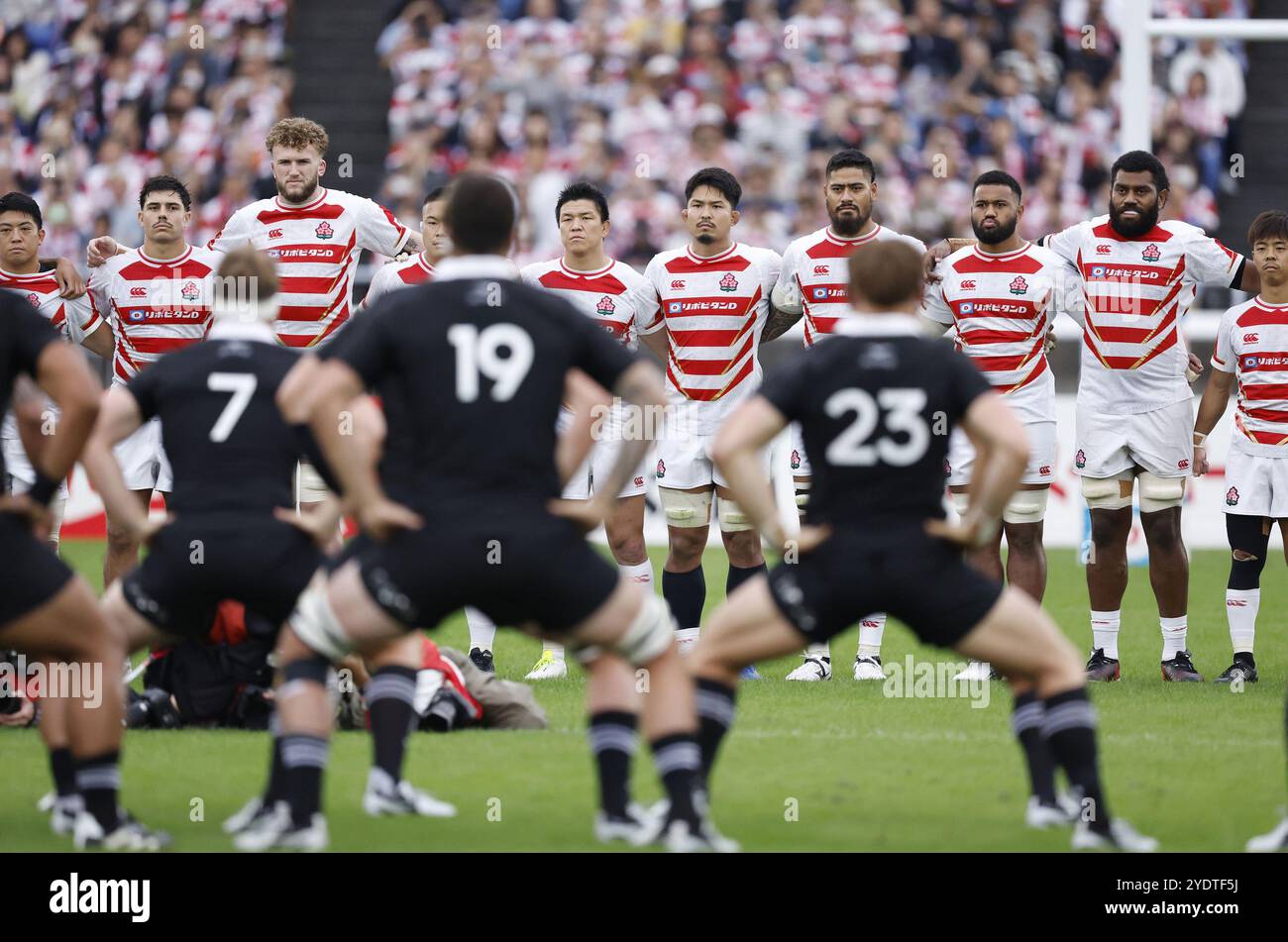 The Japan side (back) watches the New Zealand team perform the haka ...
