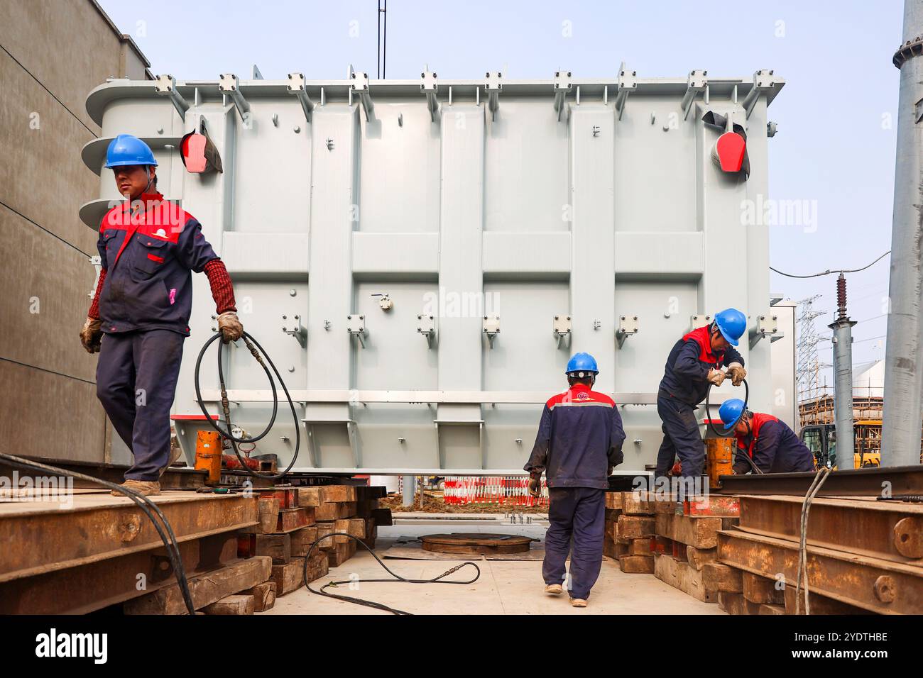 ZHENJIANG, CHINA - OCTOBER 28, 2024 - Power workers move a main transformer into place at the ...