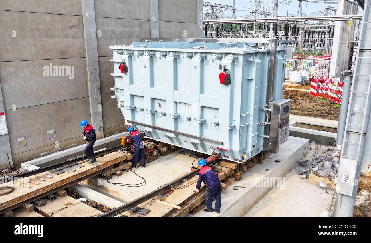 ZHENJIANG, CHINA - OCTOBER 28, 2024 - Power workers move a main ...