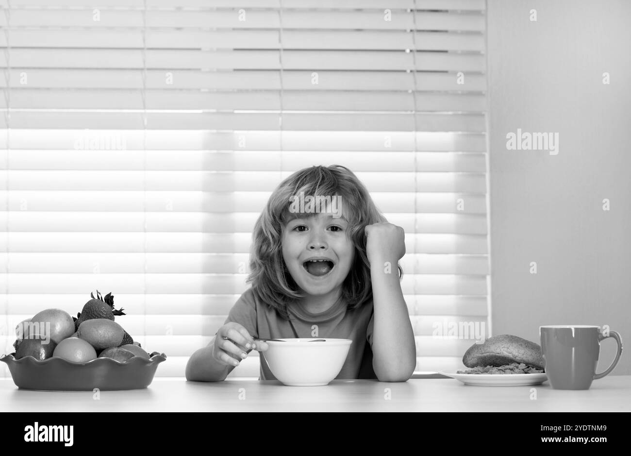 Portrait of preteen child eat fresh healthy food in kitchen at home ...