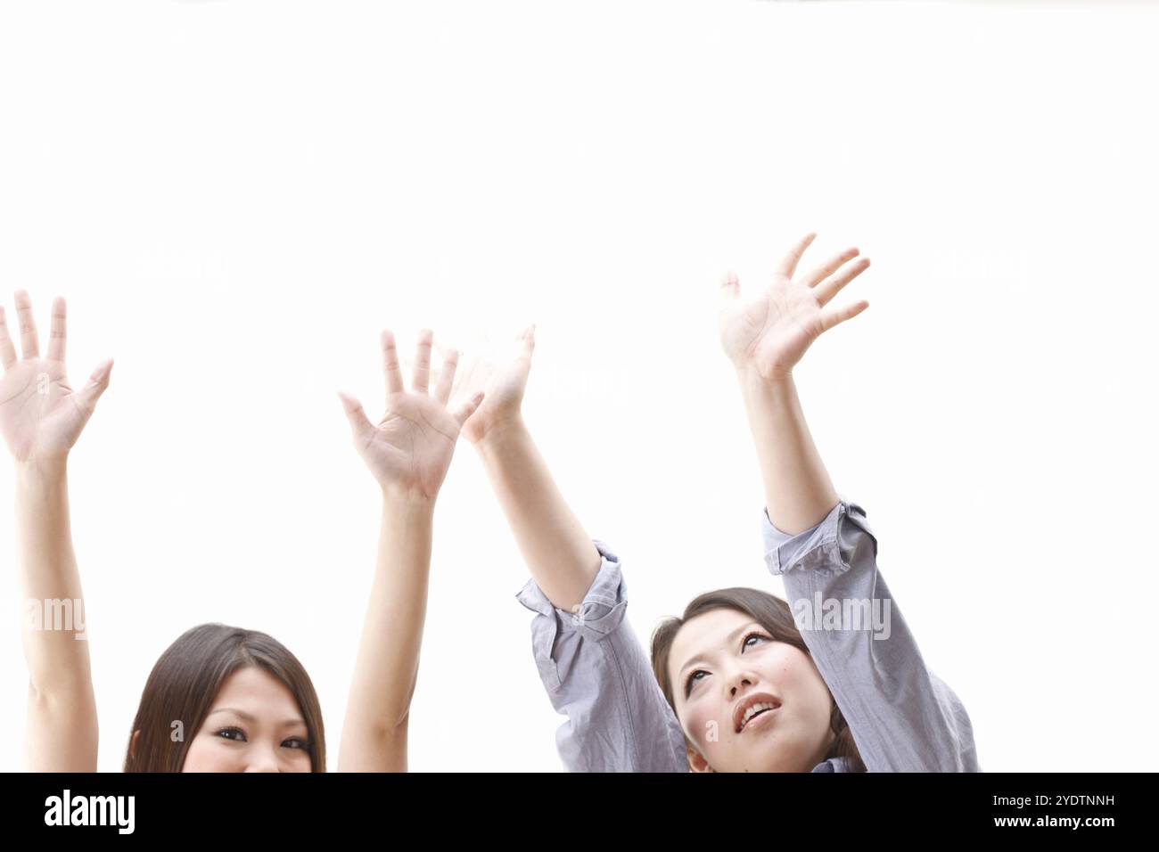 Two women raising their hands Stock Photo - Alamy