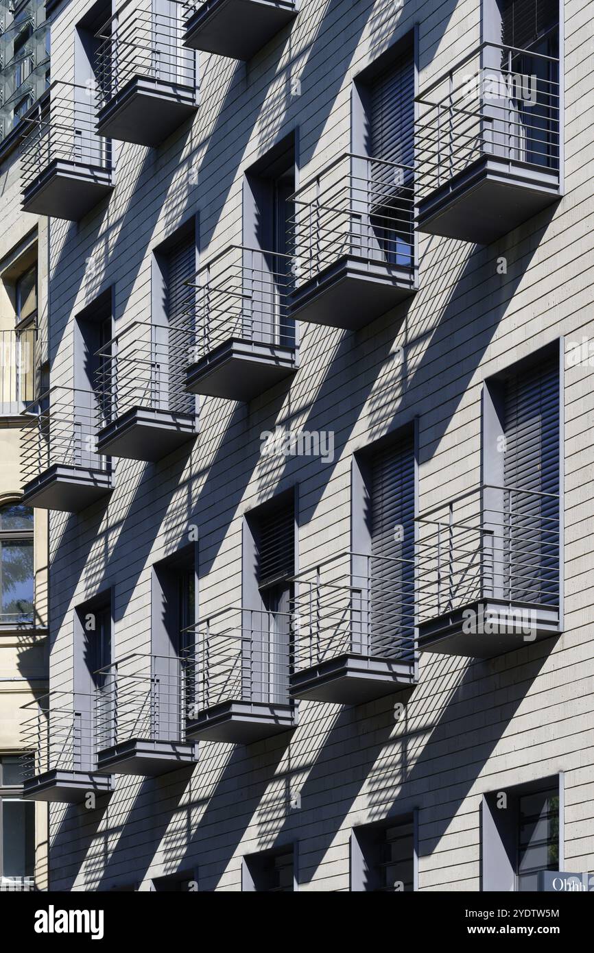 Many small balconies on a flat block cast long shadows in the evening ...