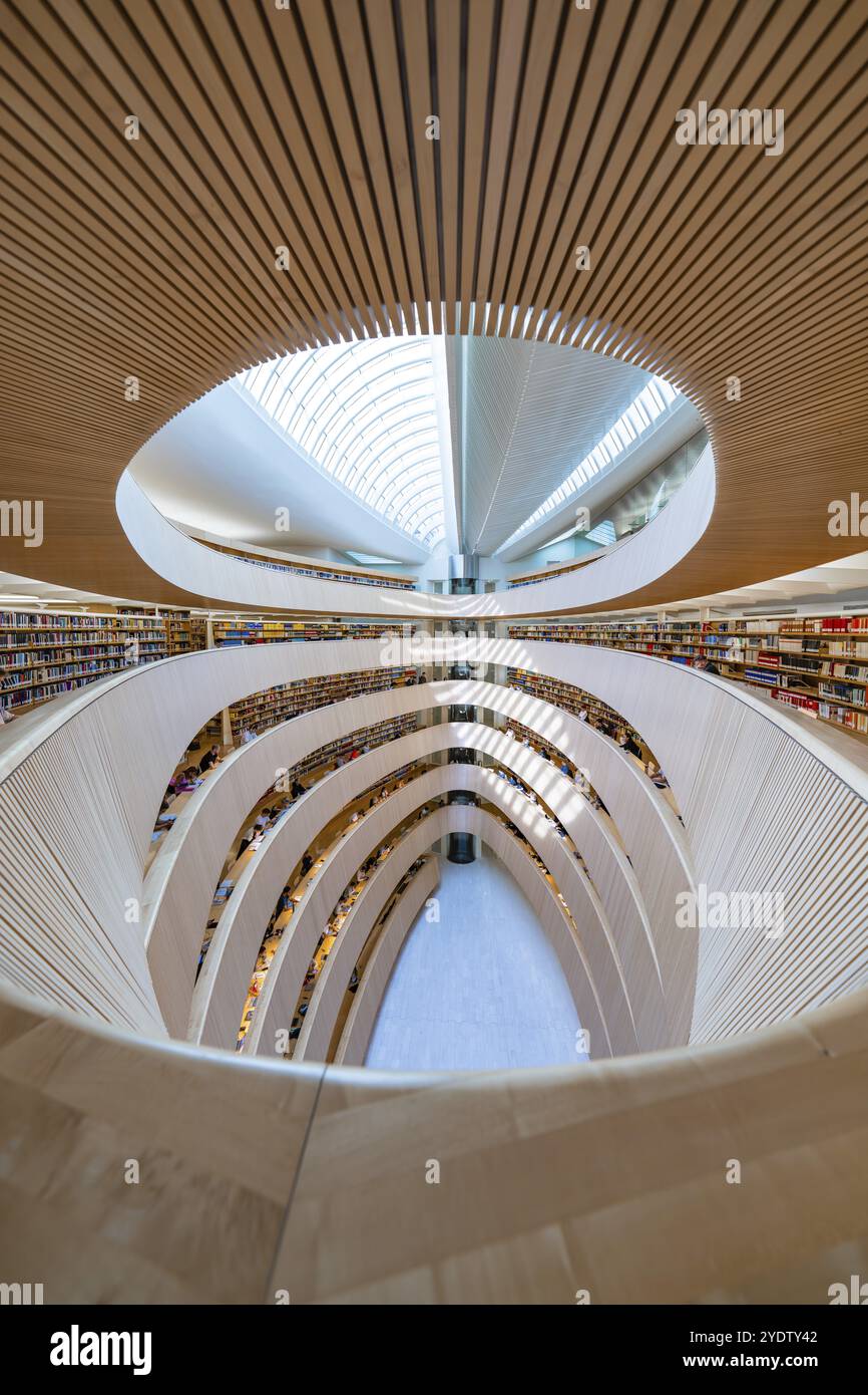 Interior view of a modern library with a spiral structure and wooden ...