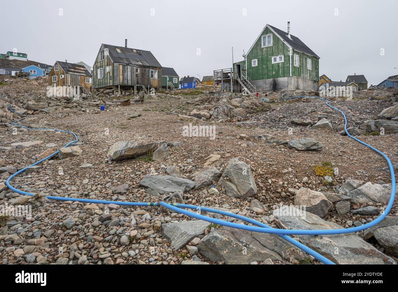 Colourful houses on stony ground, water pipe, remote Arctic Inuit ...