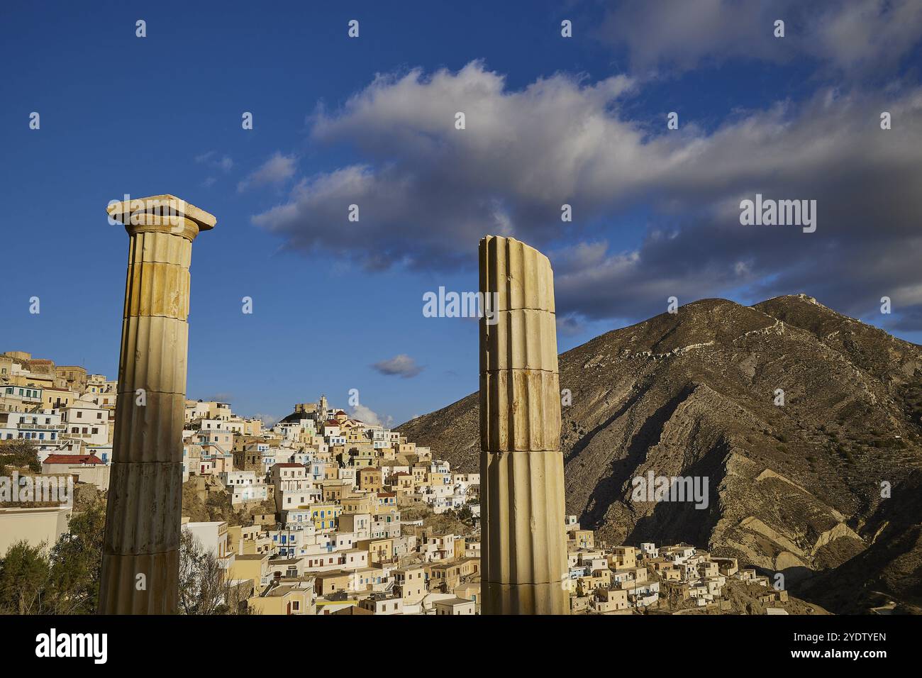 Ancient columns stand in the foreground while a village stretches out ...