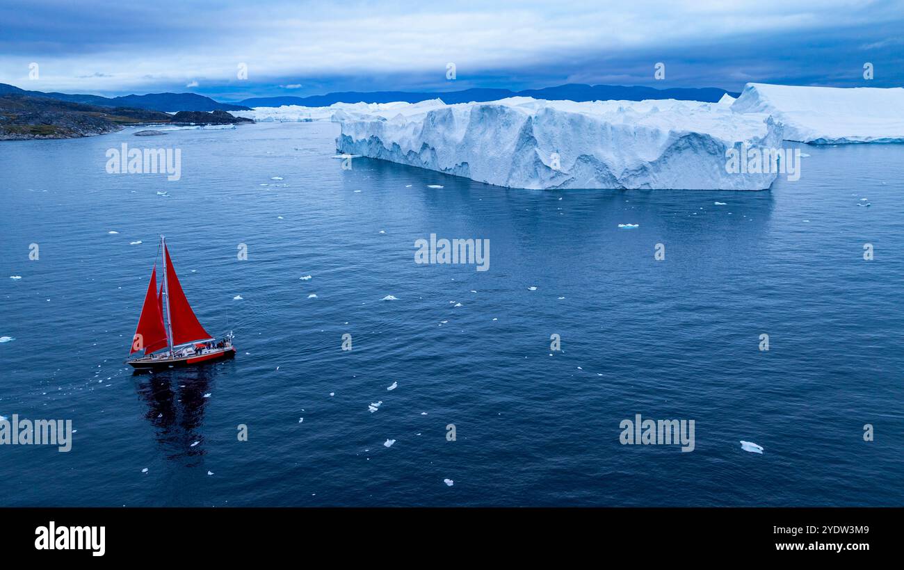 Aerial of a red sailing boat in the Ilulissat Icefjord, UNESCO World ...