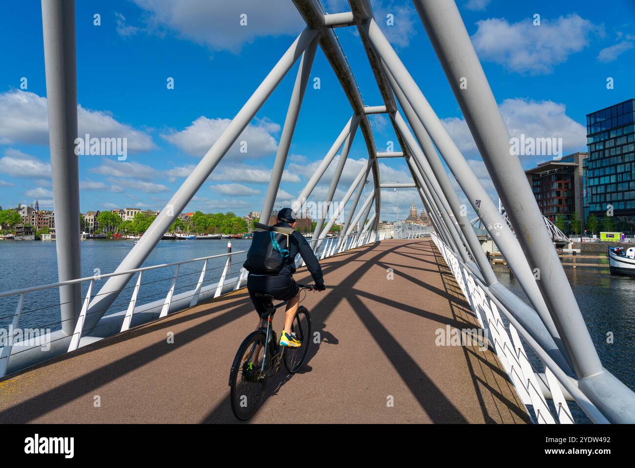 Man on bicycle riding on Mr. J.J. van der Veldebrug bridge, Amsterdam ...