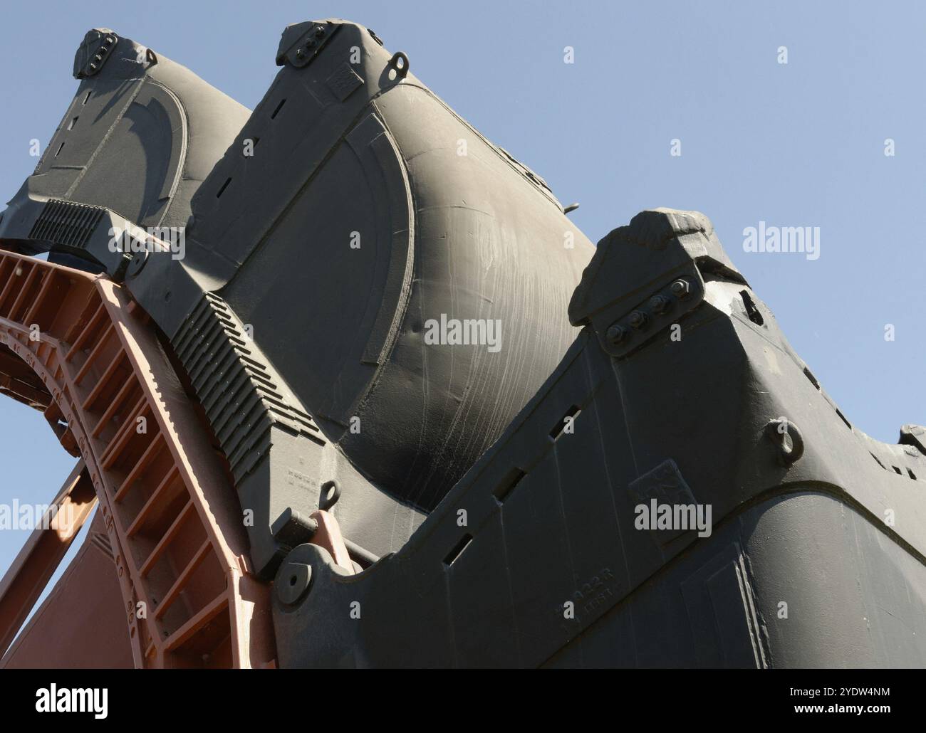 Bucket wheel of an open-cast mining excavator in front of a clear blue ...