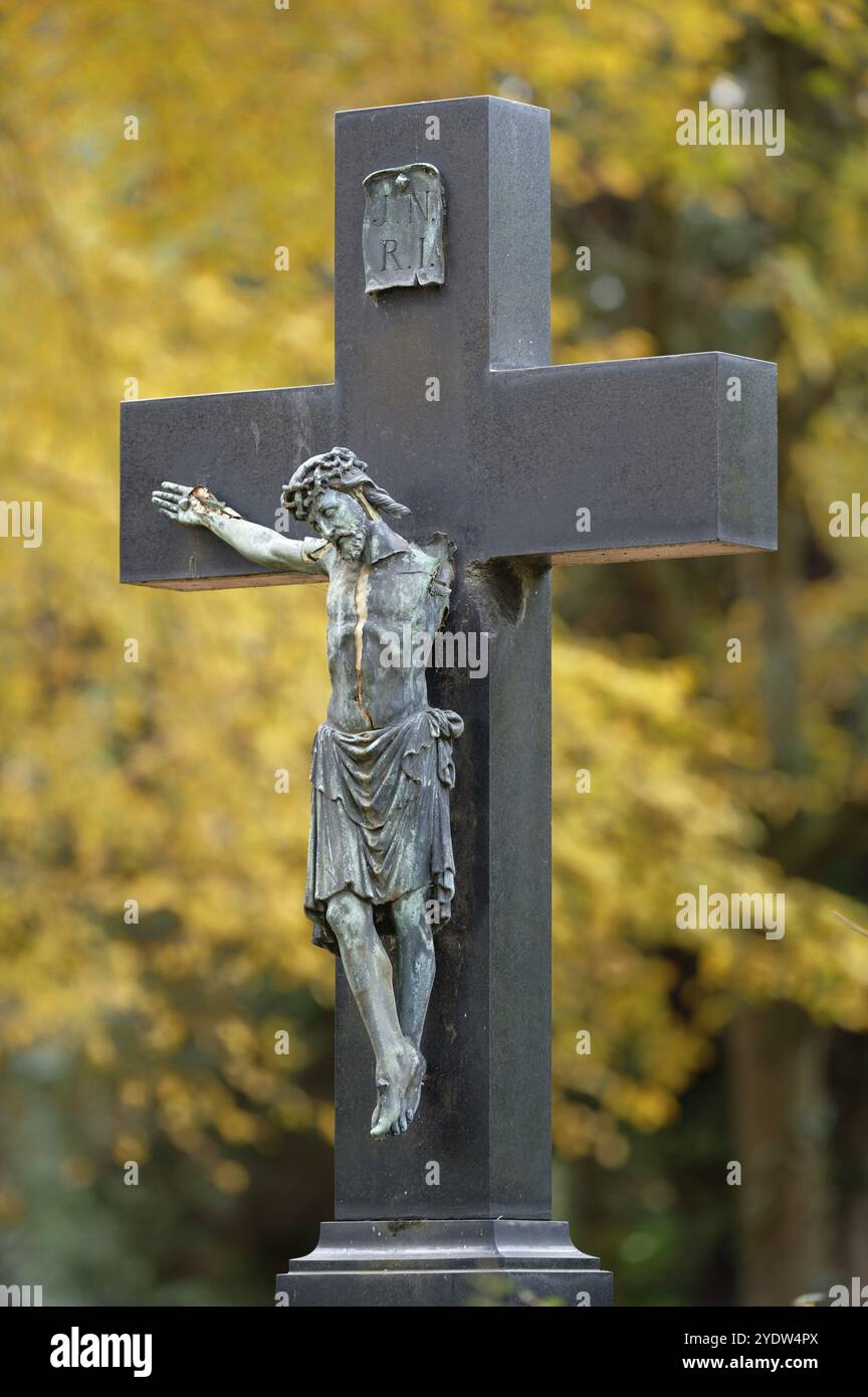 An arm is missing from a crucifix in an autumnal cemetery Stock Photo ...